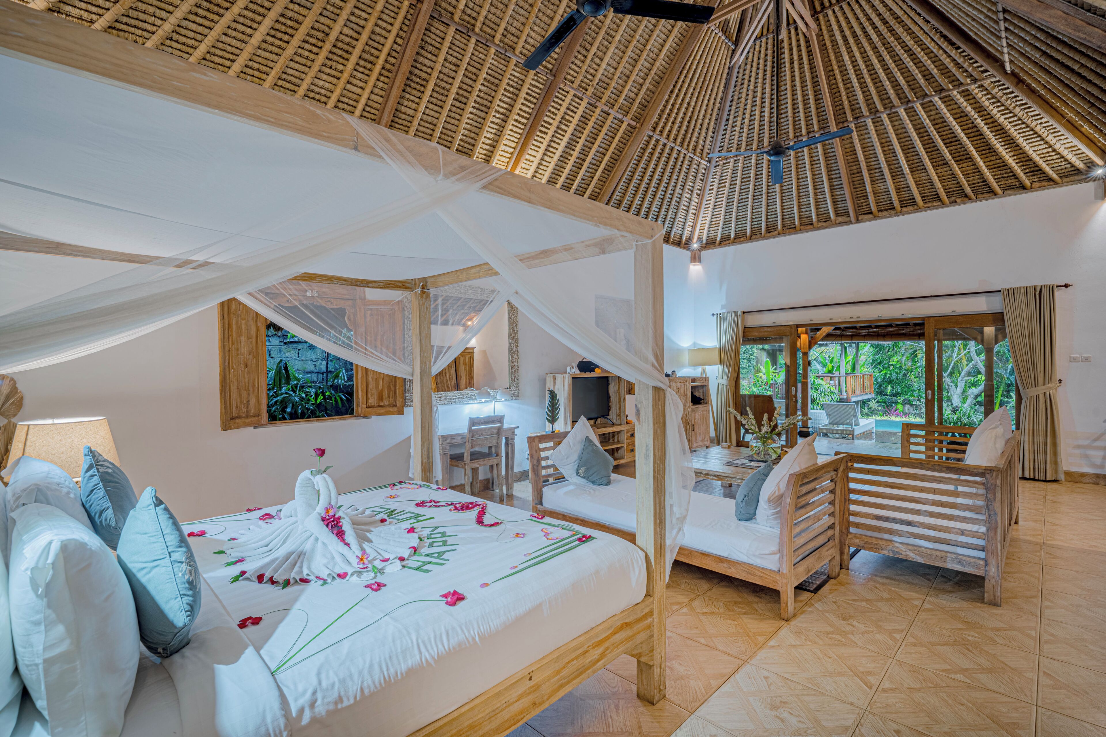 Quarto com cama, escrivaninha, cadeira e janela com vista para o verde.