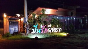 Um edifício com uma placa que diz "Thuisnsoan" e uma pequena entrada com uma parede de tijolos.