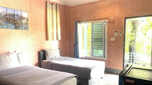 Quarto com duas camas, janela com persianas, um quadro na parede e um balcão de atendimento.