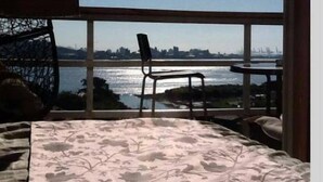 Uma varanda com vista para um corpo d'água e o horizonte da cidade.