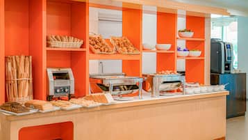 Um balcão de buffet com diversos alimentos e uma máquina de café.