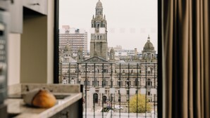 Vista de um edifício histórico com uma torre imponente vista pela janela.