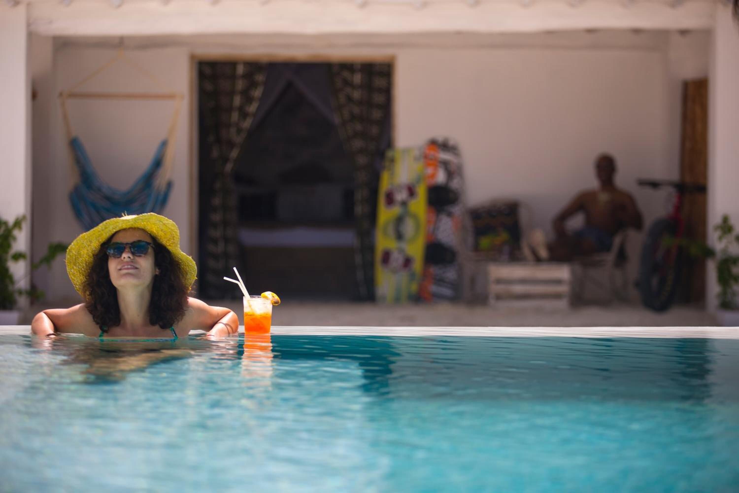 Uma pessoa em uma piscina com uma bebida.
