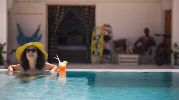 Uma pessoa em uma piscina com uma bebida.