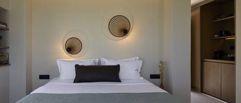 Quarto moderno com uma cama grande, duas luminárias fixadas na parede, um guarda-roupa de madeira e uma pequena planta.