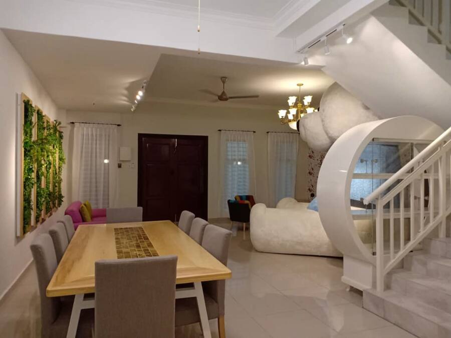 Uma sala de estar moderna com uma mesa de jantar de madeira, um sofá e uma escada em espiral.