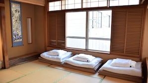 Um quarto japonês tradicional com tatames, biombos shoji e futons.