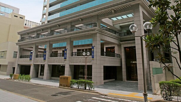 Um hotel moderno com estrutura de vários andares, grandes janelas e entrada destacada com área coberta.