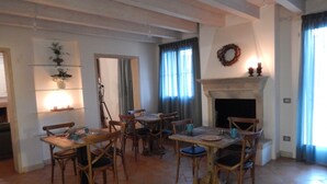 Uma sala de jantar com móveis de madeira, lareira e um espelho.