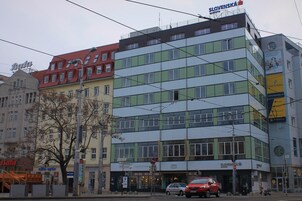 Edifício moderno com vários andares, combinando elementos de vidro e metal.