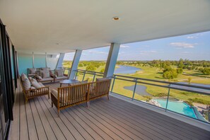 Uma varanda com vista para um campo de golfe e um lago.
