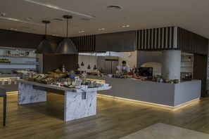 Cozinha moderna com bancadas de mármore, iluminação pendente e ilha central.