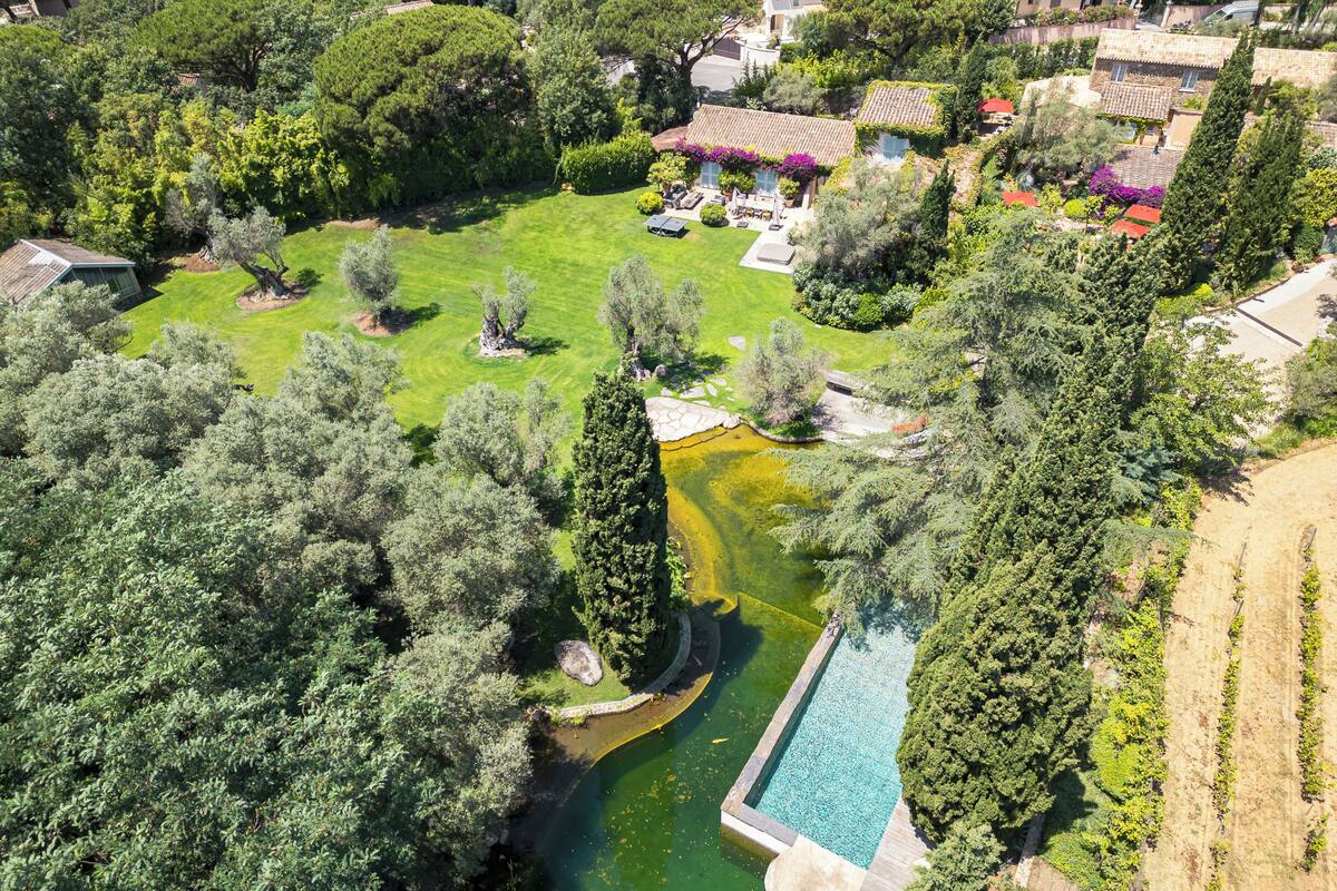 Vista aérea de um bairro residencial com piscina, muita vegetação e casas.