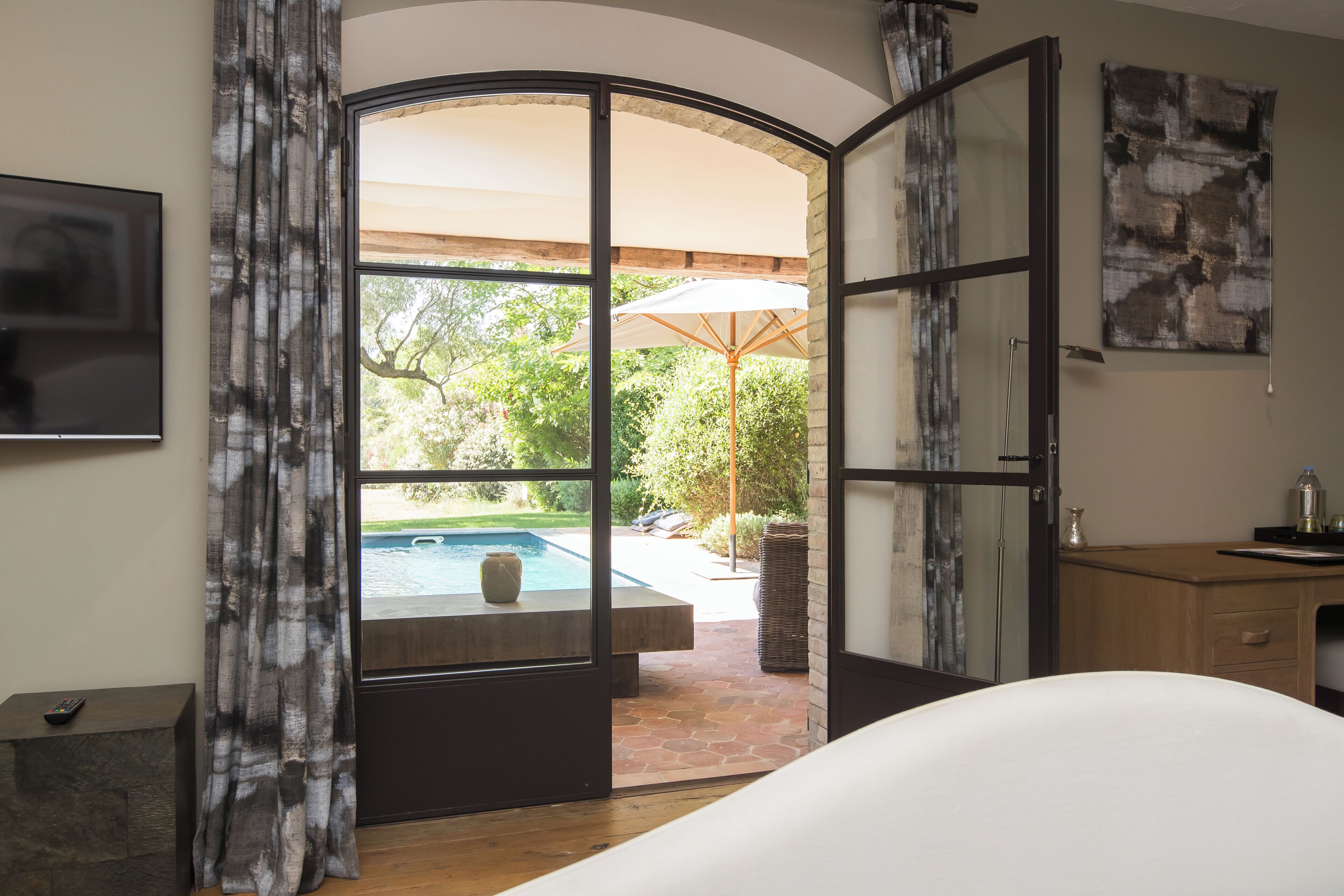 Quarto com vista para uma piscina exterior e zona de terraço.