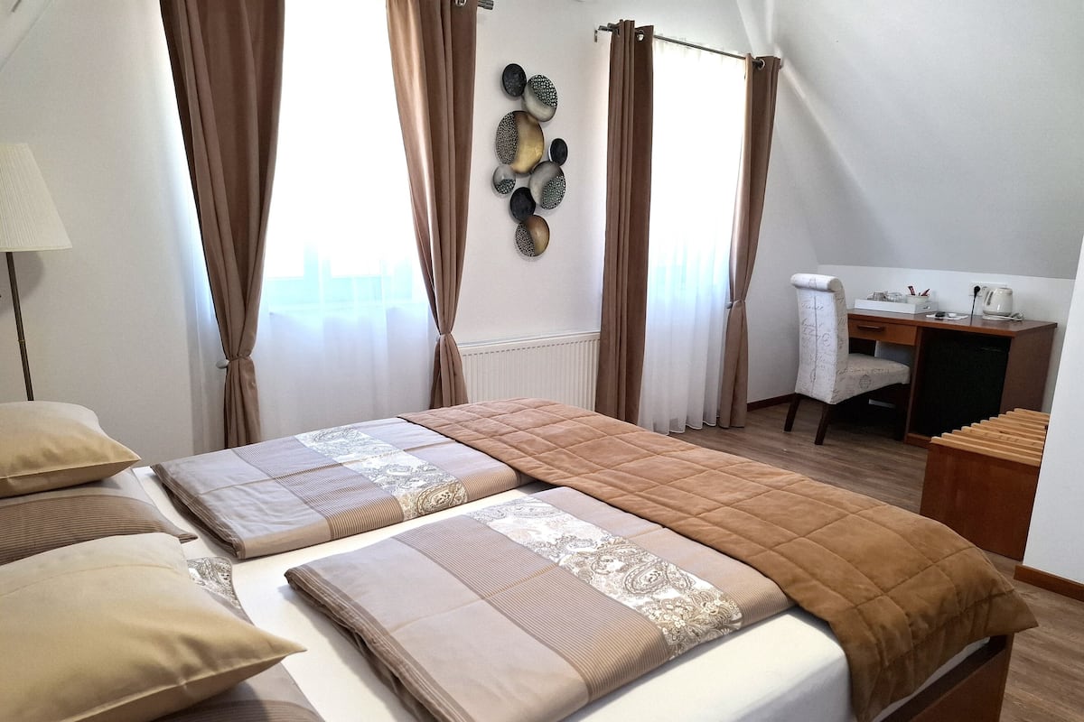 Quarto com cama, escrivaninha e cadeira.