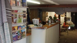 Um quarto pequeno e desarrumado com um balcão de madeira e estantes cheias de livros.