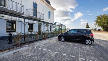 Um edifício moderno com um carro preto estacionado em frente.