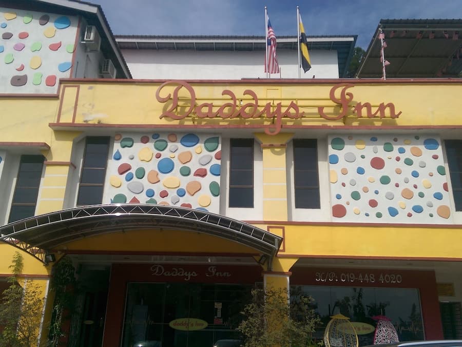 Um edifício com fachada colorida e a inscrição "Daddy's Inn" bem visível.