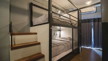 Quarto com beliche, escada de madeira e ventilador de teto.