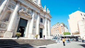 Um edifício imponente com arquitetura clássica, com colunas grandes e esculturas detalhadas.
