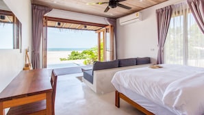 Quarto com cama, sofá, mesa de jantar e ventoinha no teto.