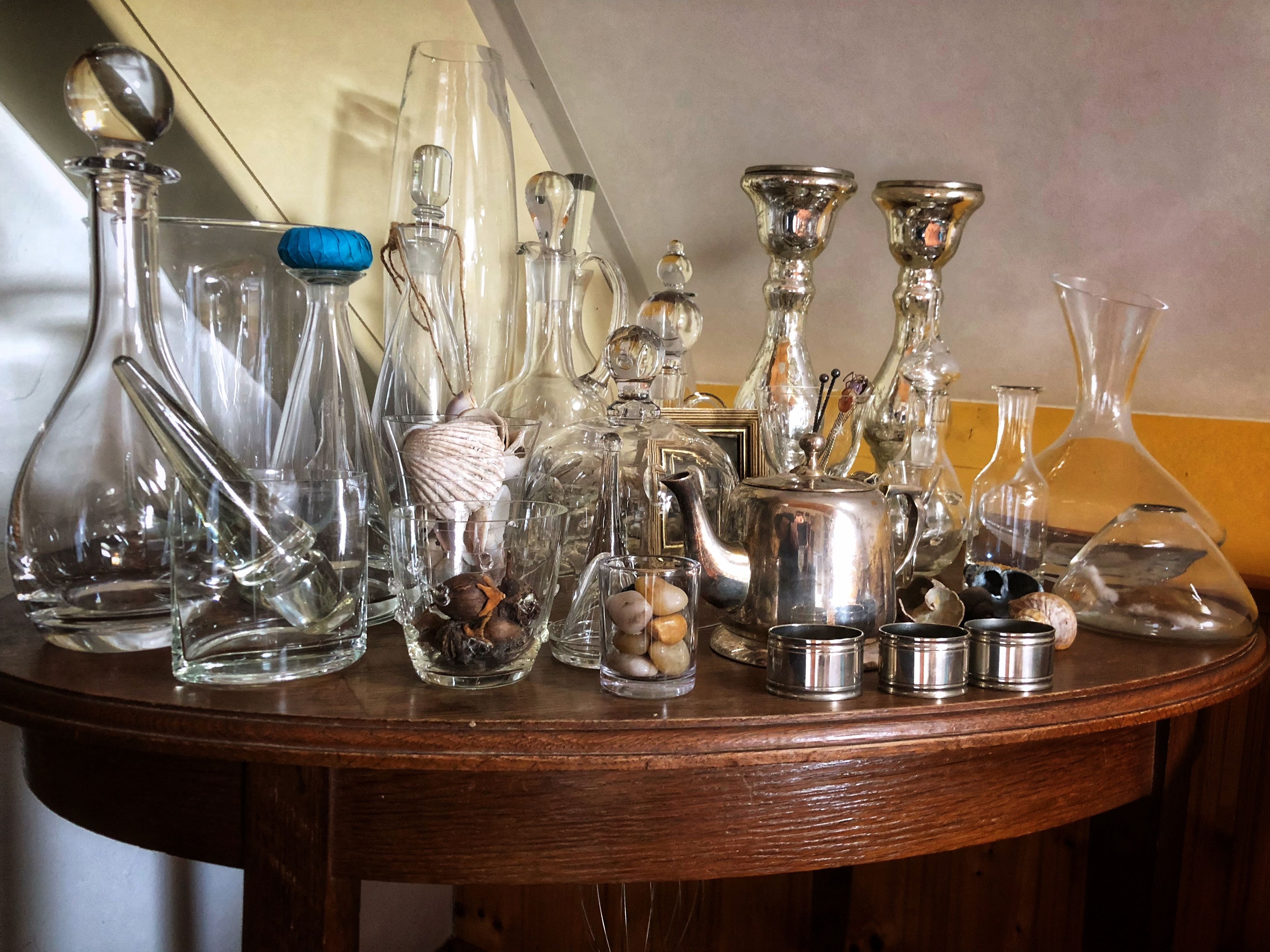 Diversos copos e recipientes metálicos sobre uma mesa de madeira.