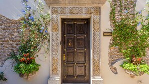 Uma porta de madeira tradicional com uma placa em cima que diz 'INASTIA'.