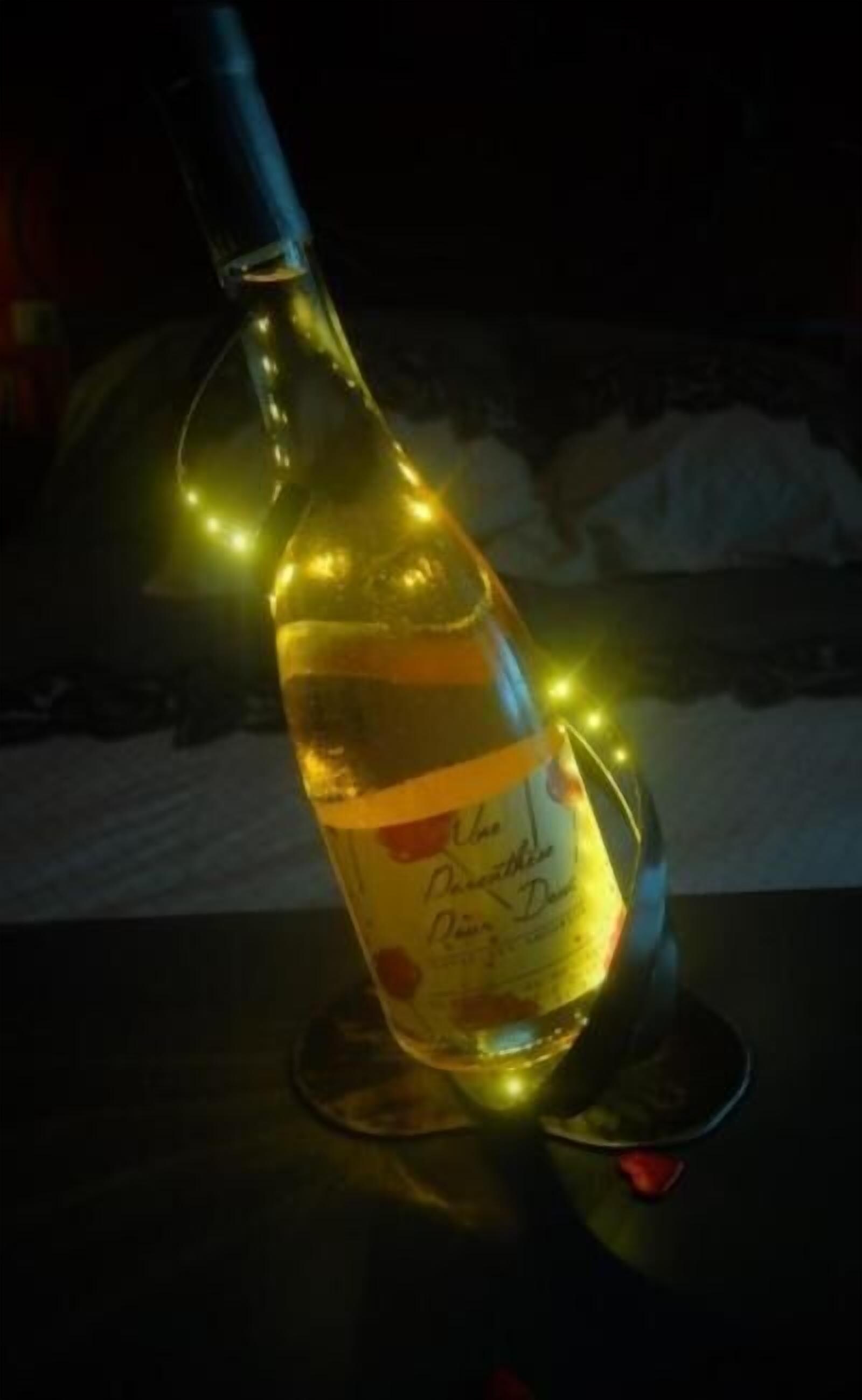 Uma garrafa de vinho com etiqueta, apoiada num apoio para copos.