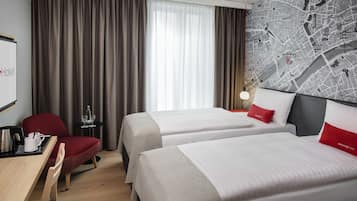 Quarto de hotel com duas camas, uma escrivaninha com cafeteira, uma cadeira e um mapa na parede.
