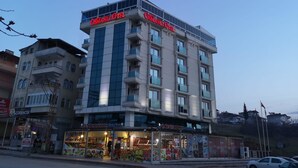 Um hotel com vários andares e uma placa vermelha em destaque com a inscrição 'OSMANLI OTEK'.
