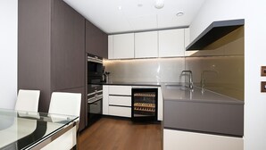 Uma cozinha moderna com uma mesa de jantar de vidro, eletrodomésticos embutidos e um design elegante.