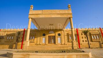 Uma entrada imponente com uma placa que diz 'Desert Dream Royal Camp'.