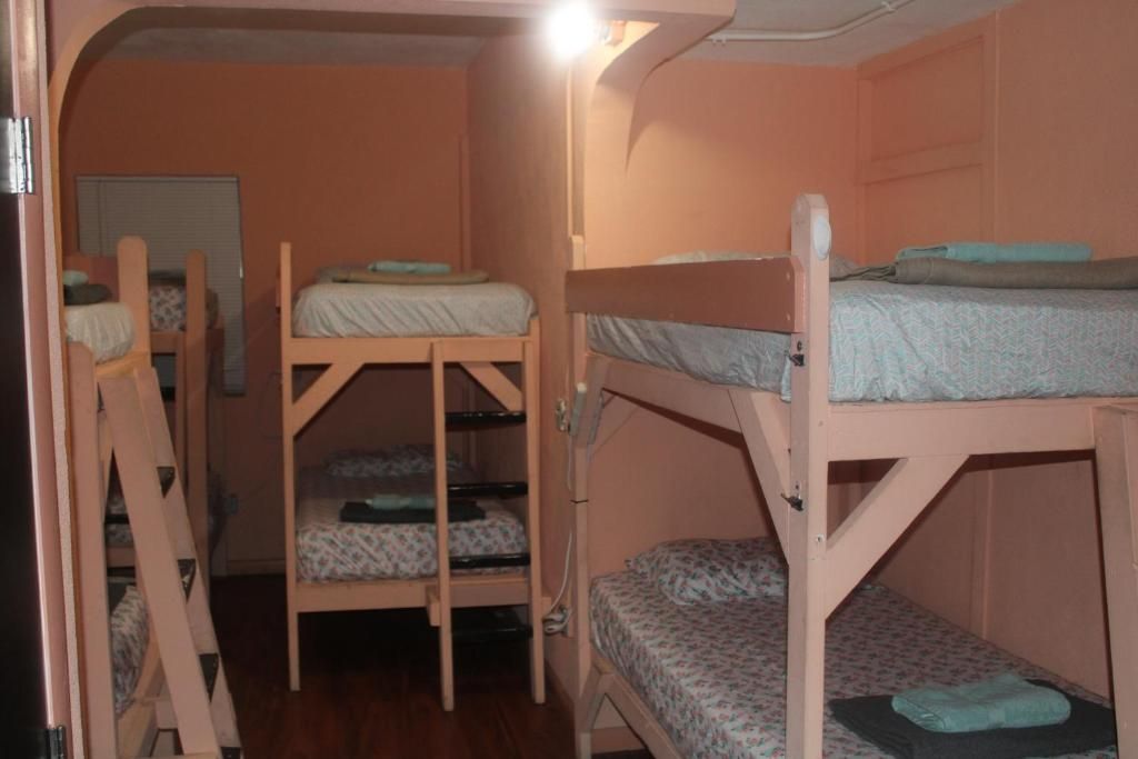 Quarto com beliche, cadeira e mesa pequena.