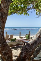 Praia particular, areia branca, espreguiçadeiras, guarda-sóis 