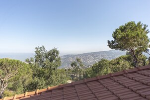Terraço no telhado com vista para a paisagem urbana e o mar.