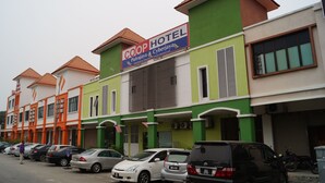 Uma fileira de edifícios com uma placa indicando 'Coop Hotel' e 'Putrajaya & Cyberjaya'.