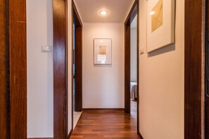 Um corredor com portas de madeira e um quadro pendurado na parede.