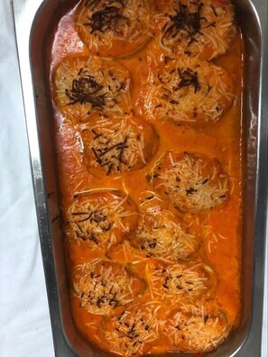 Uma bandeja de comida com molho cremoso alaranjado e queijo ralado por cima.