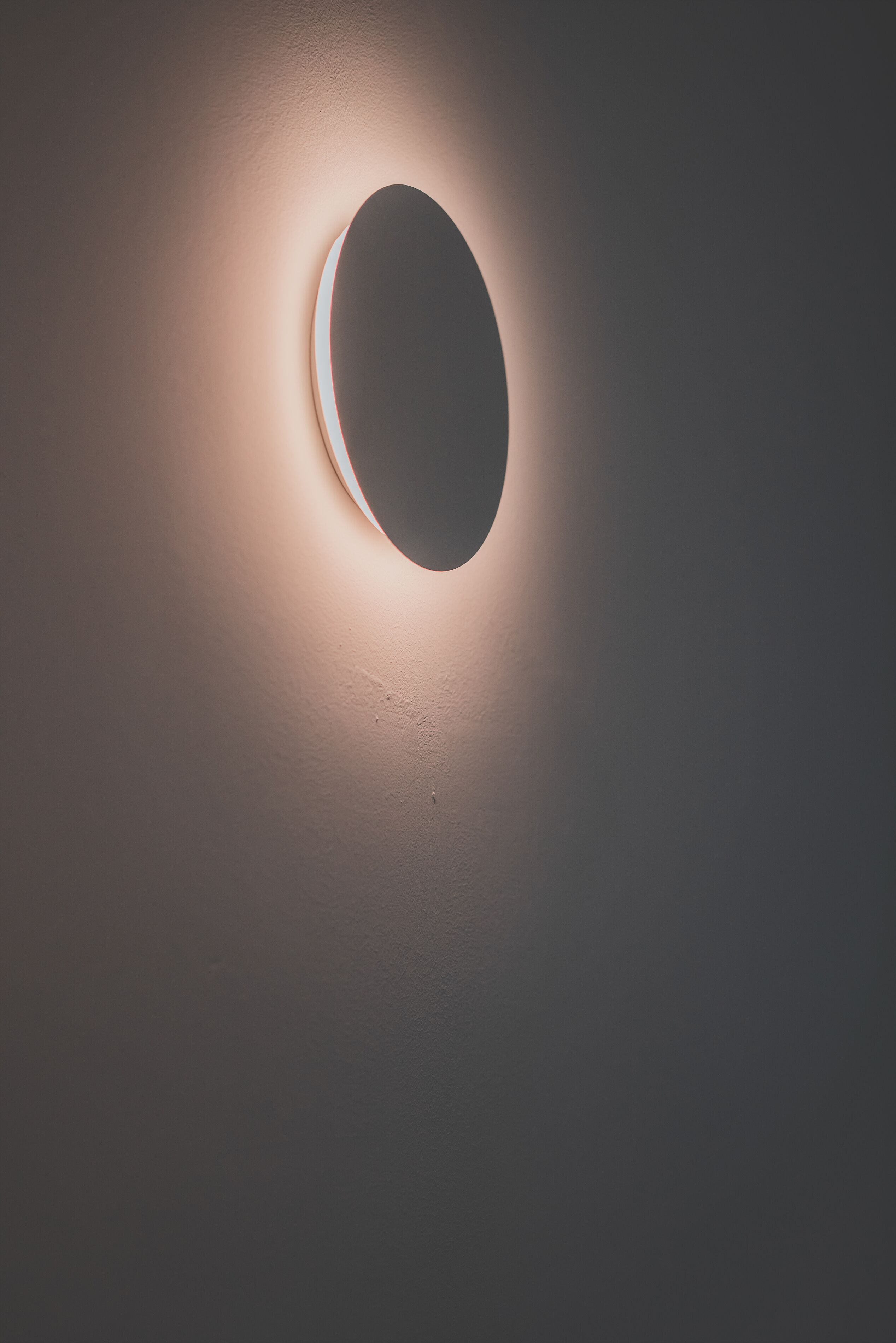 Luminária circular fixada na parede.