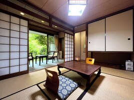 Um quarto japonês tradicional com tatames, uma mesa baixa e portas deslizantes.