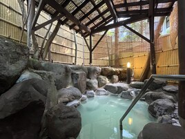 Um espaço interno com paisagem rochosa e um elemento aquático.