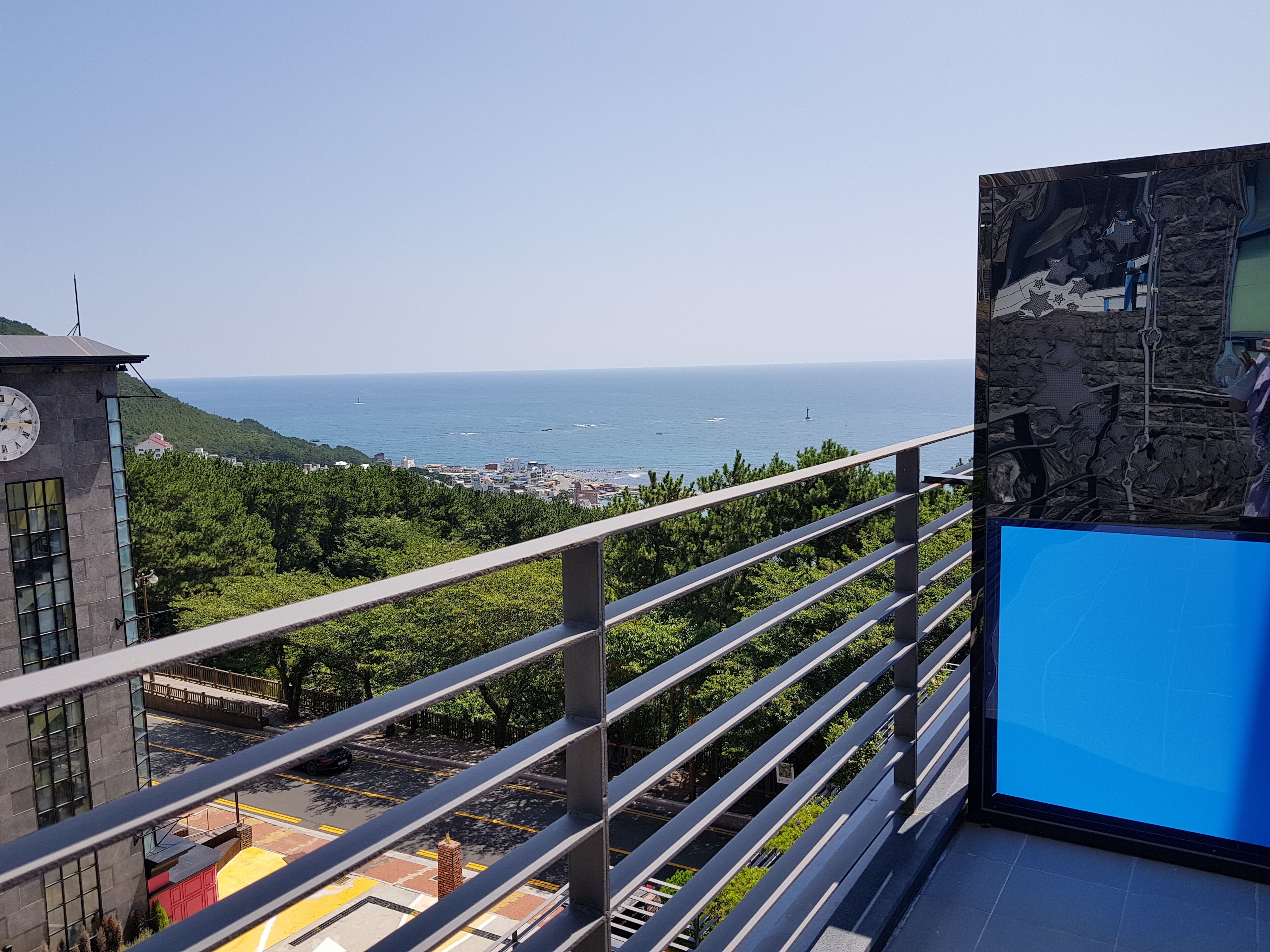 Uma varanda com vista para o mar e um campanário.