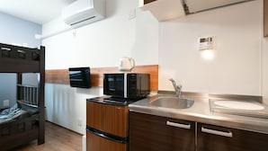 Cozinha compacta com micro-ondas, cafeteira e pia.
