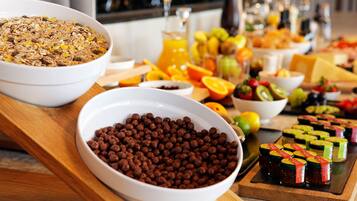 Um buffet de café da manhã com diversos alimentos e bebidas.