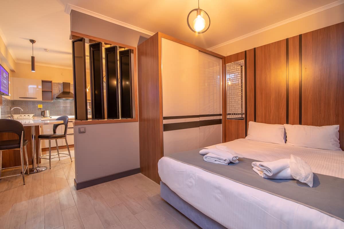 Quarto de hotel com cama, escrivaninha e uma cadeira.