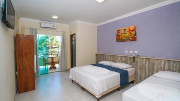 Quarto de hotel com duas camas, uma televisão e um quadro na parede.