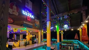 Uma área de bar com iluminação colorida e banquetas.