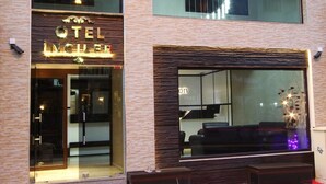 Entrada de hotel com uma placa que diz 'HOTEL INCHER'.
