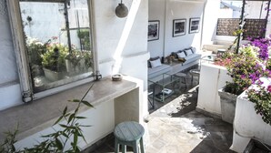Um terraço no telhado com área de refeições, espaço para sentar e plantas em vasos.