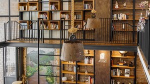 Um loft espaçoso com teto alto, paredes de tijolo aparente e um mezanino.